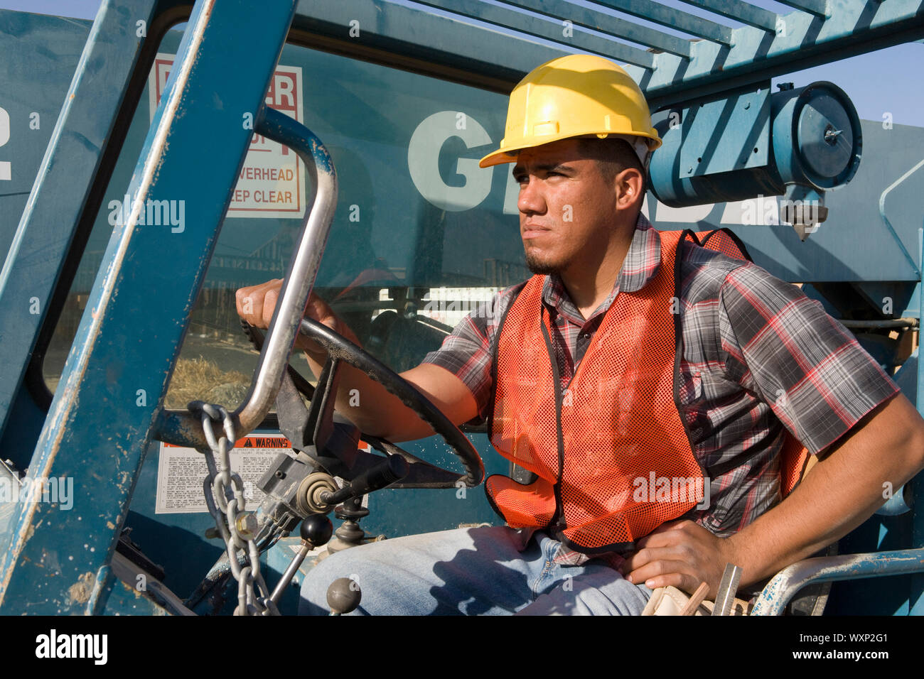 Construction worker driving vehicle Stock Photo - Alamy