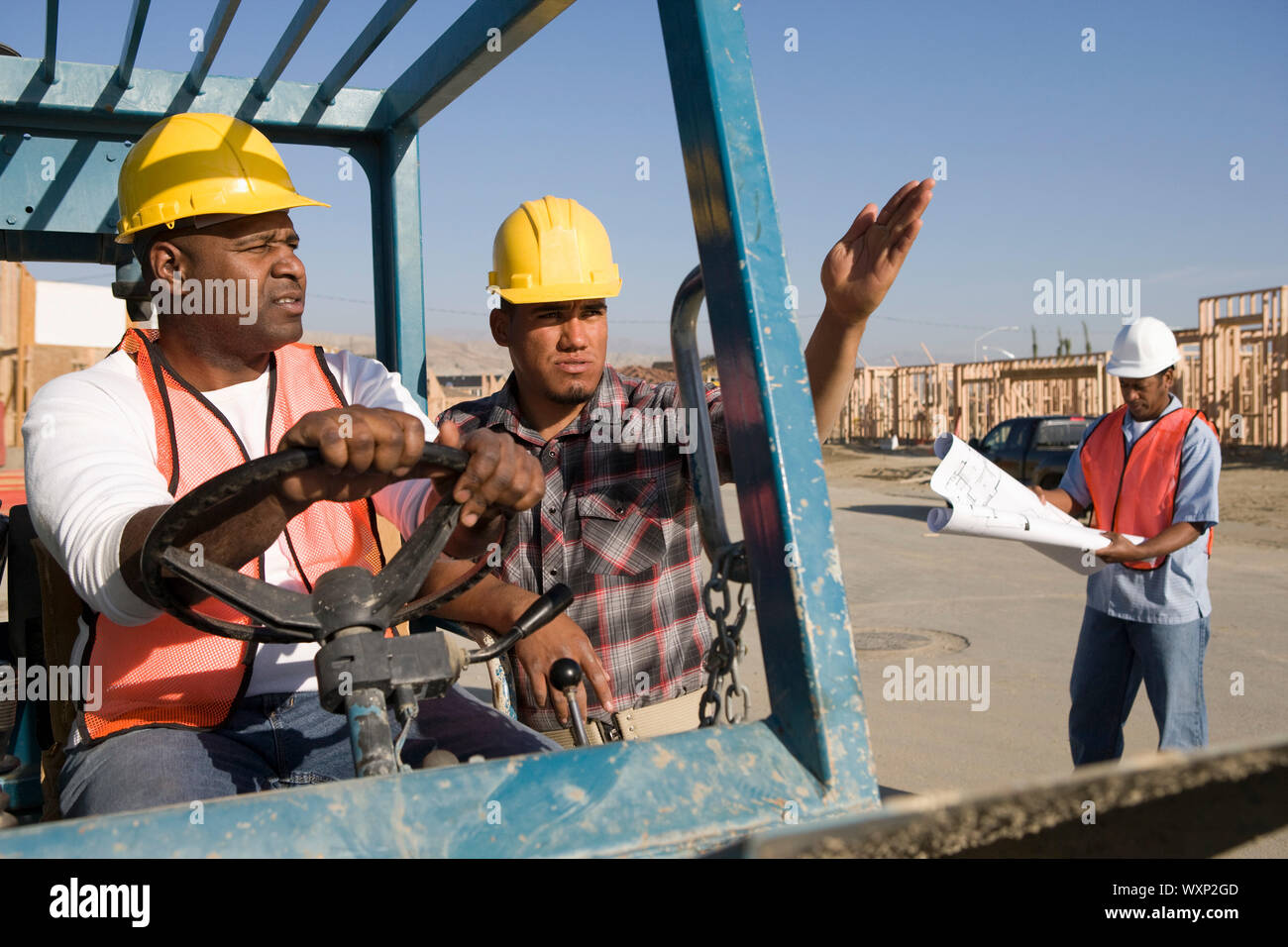 Construction worker showing direction to another worker steering ...