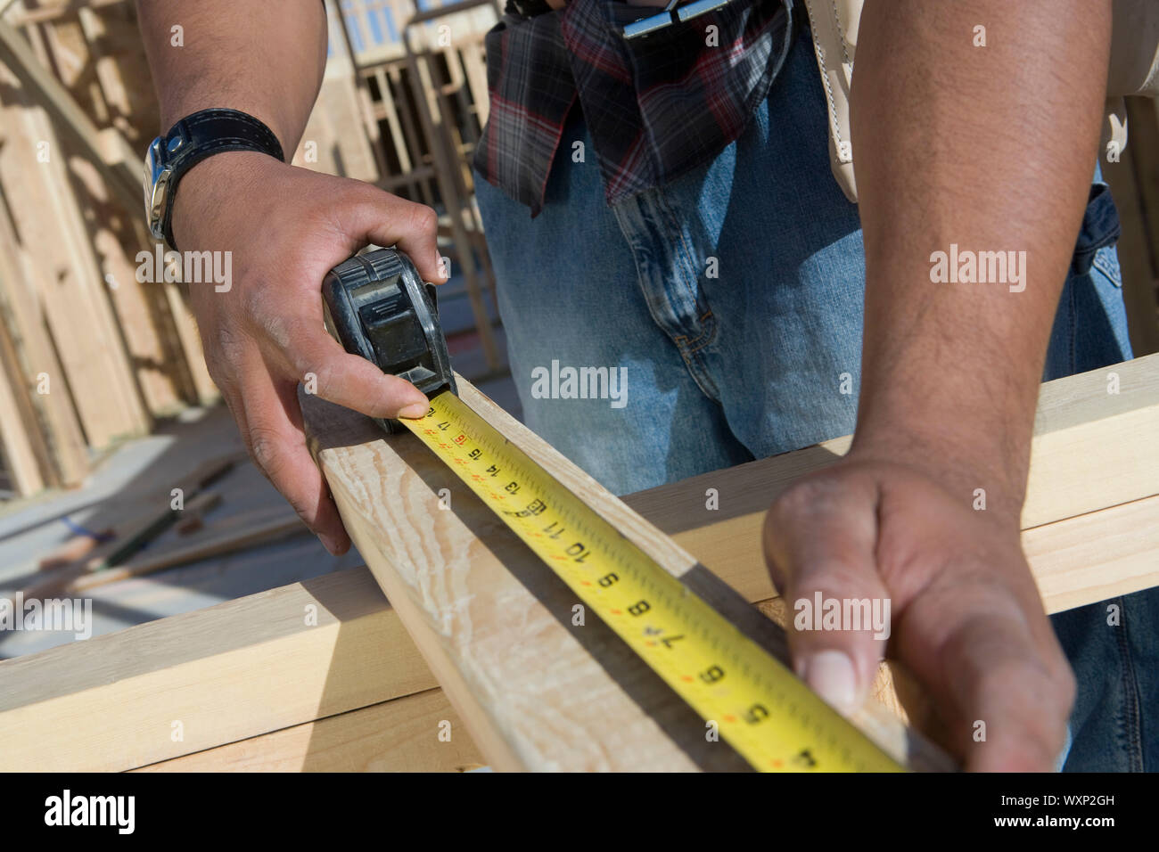 Man measuring half constructed wall with tape measure Stock Photo - Alamy