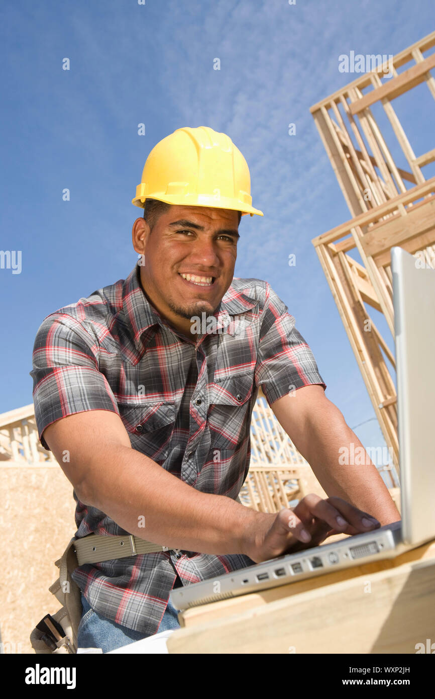 Construction worker using laptop Stock Photo - Alamy