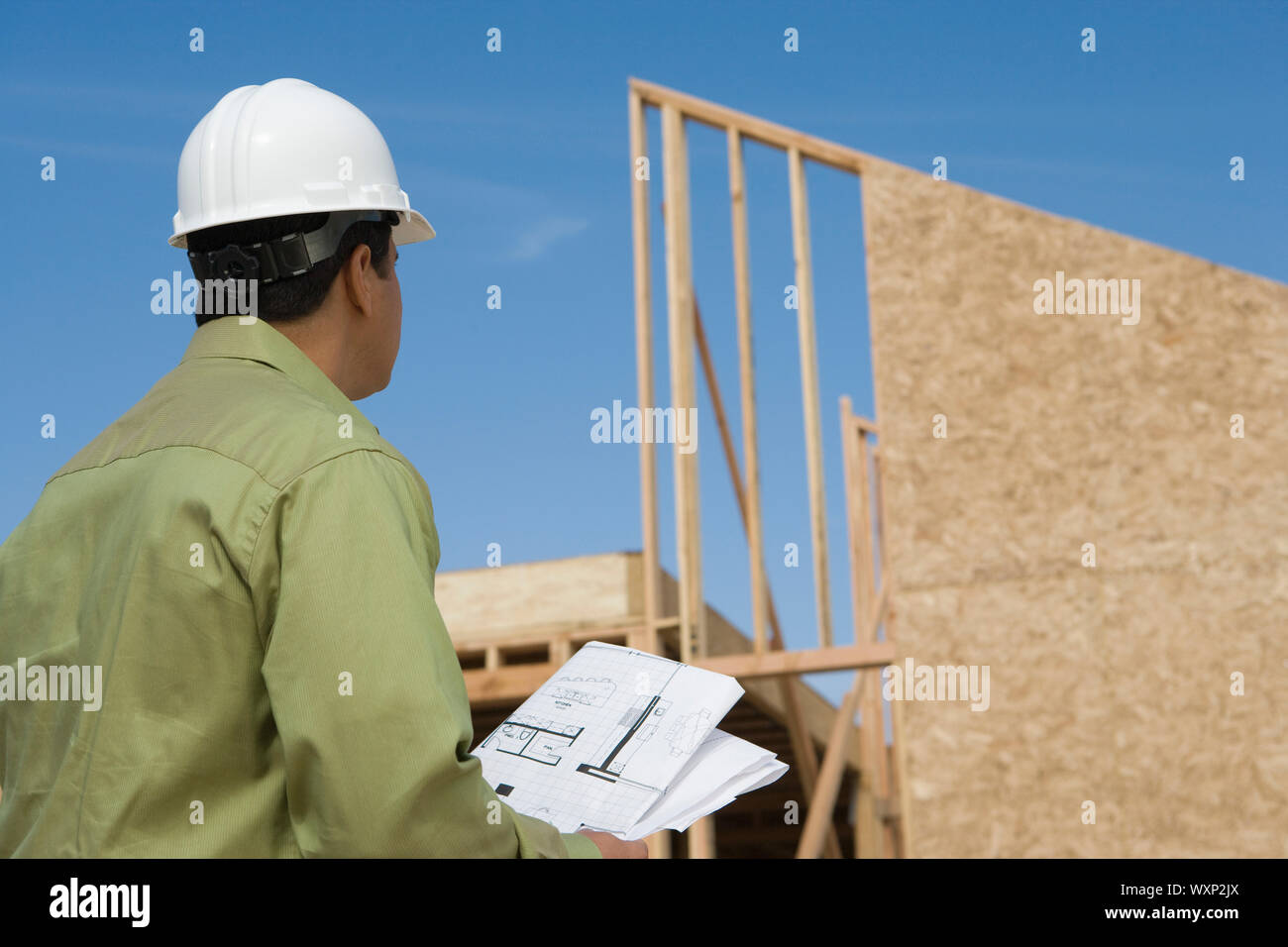 Architect holding blueprints on construction site Stock Photo - Alamy
