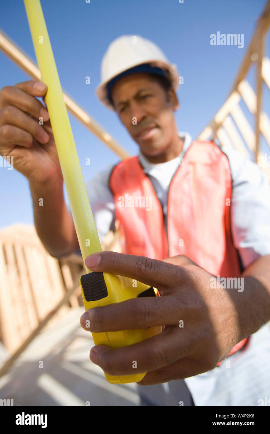 Construction worker measuring with tape measure Stock Photo - Alamy