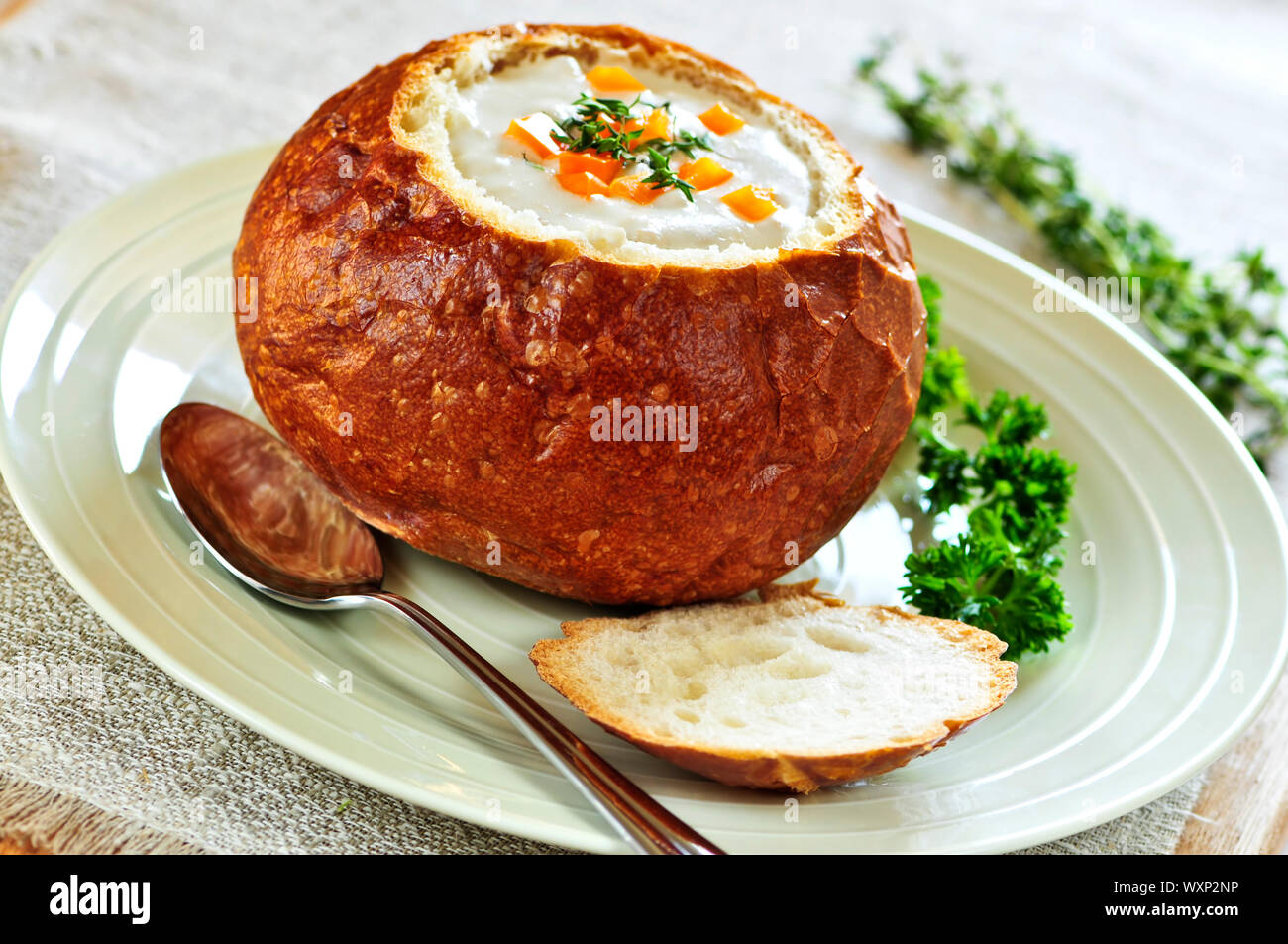 Lunch of soup served in baked round bread bowl Stock Photo - Alamy