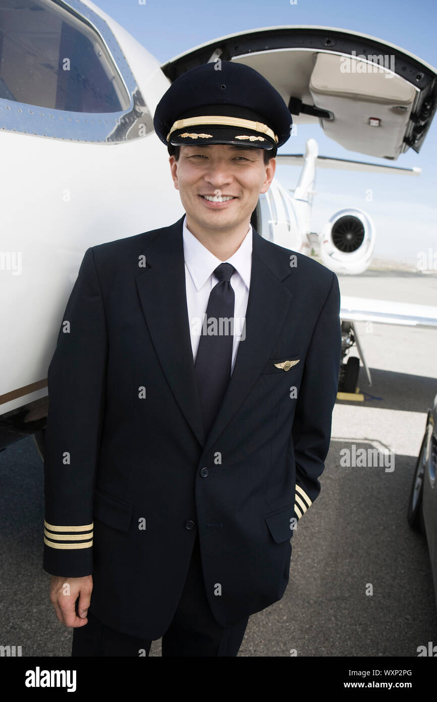 Asian male pilot in front of airplane, elevated view Stock Photo - Alamy