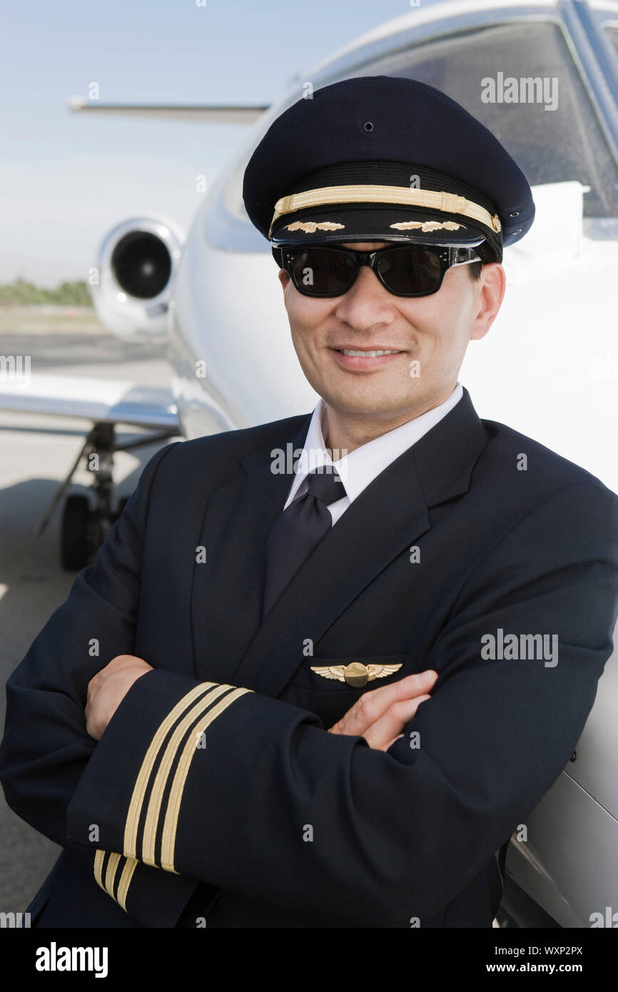 Portrait of Asian male pilot in front of private jet Stock Photo - Alamy