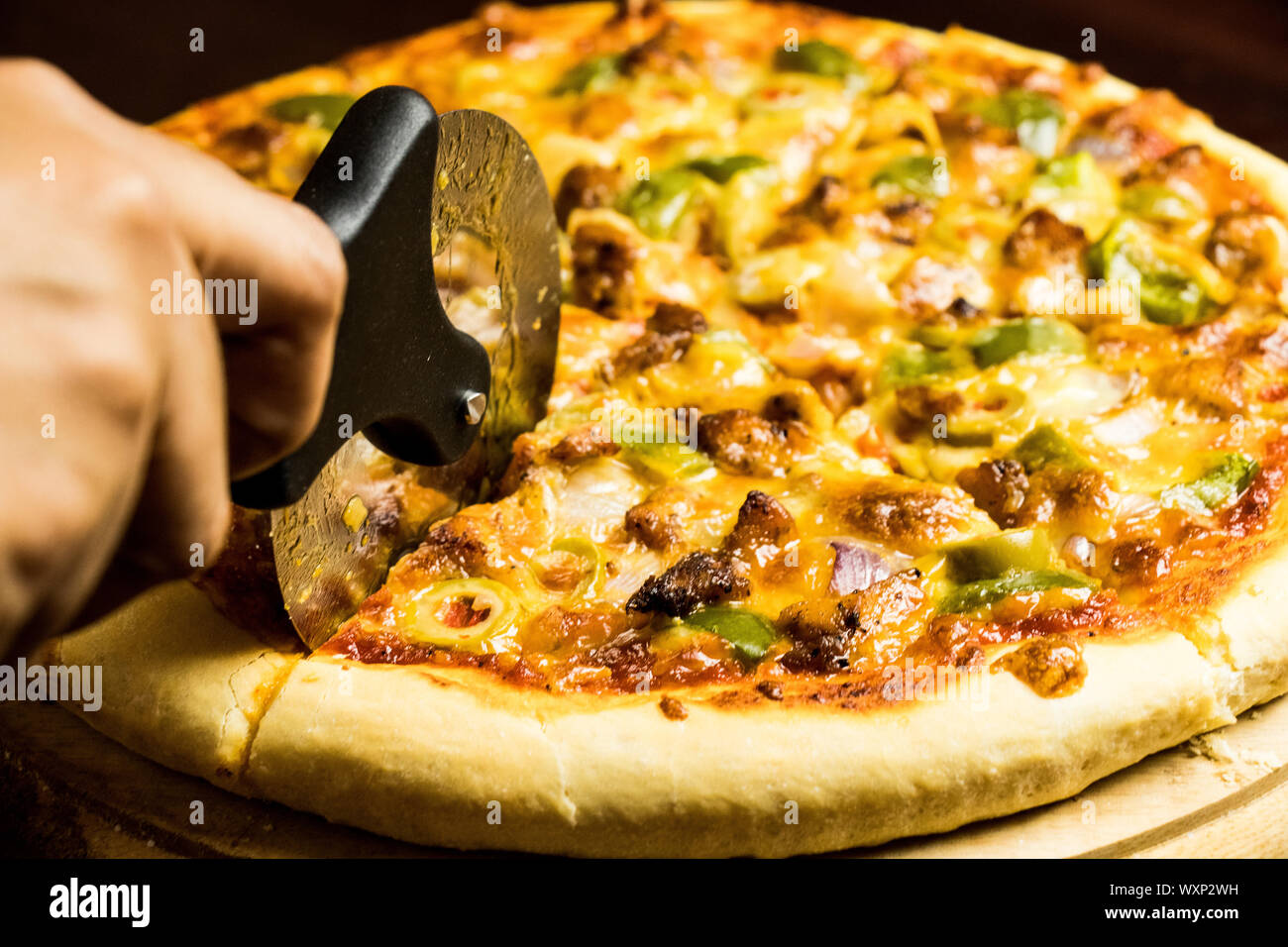 Pan Pizza cutting side closeup with dark brown wood Stock Photo - Alamy