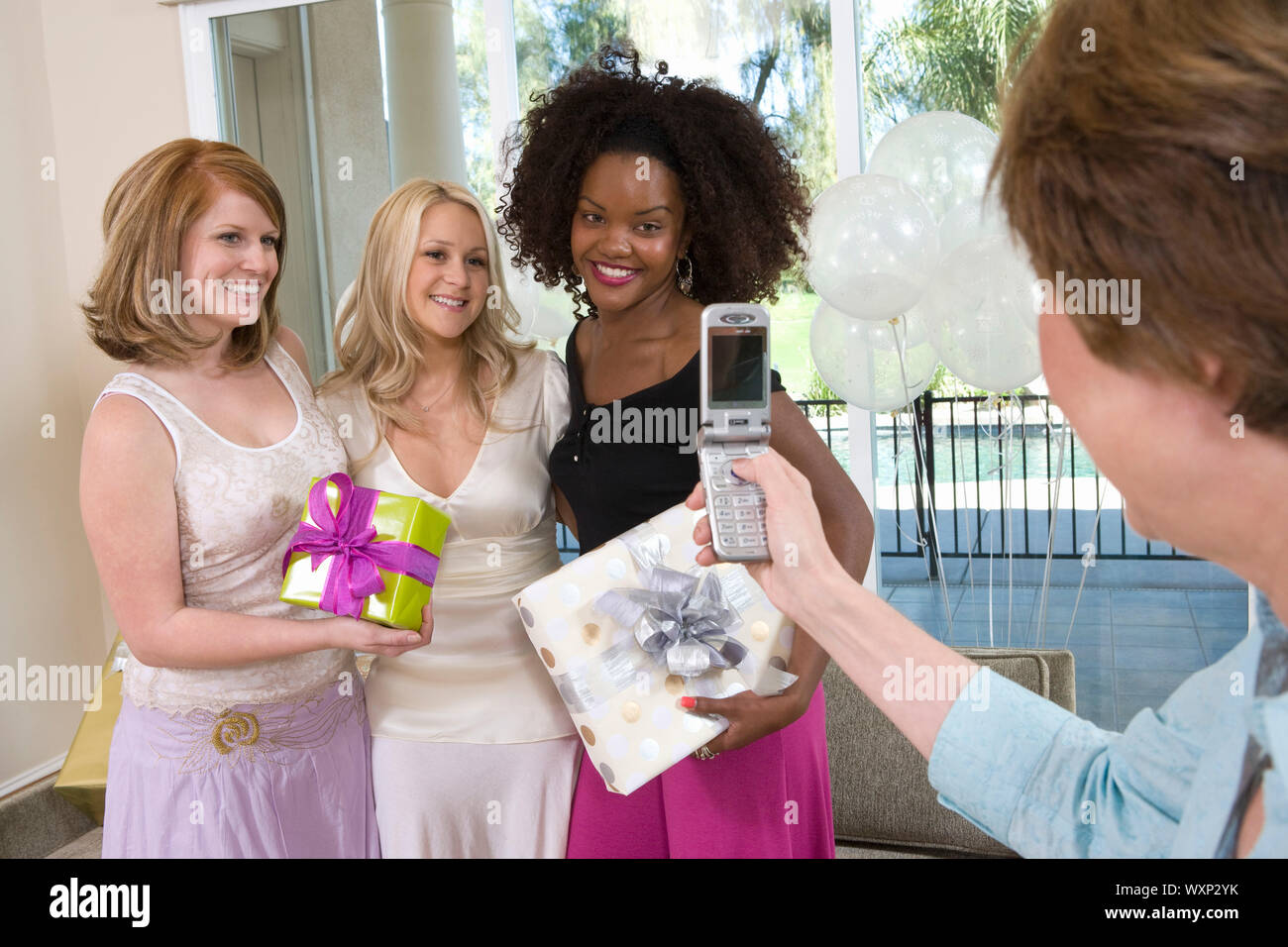 Woman Taking Pictures of women friends at Party Stock Photo - Alamy