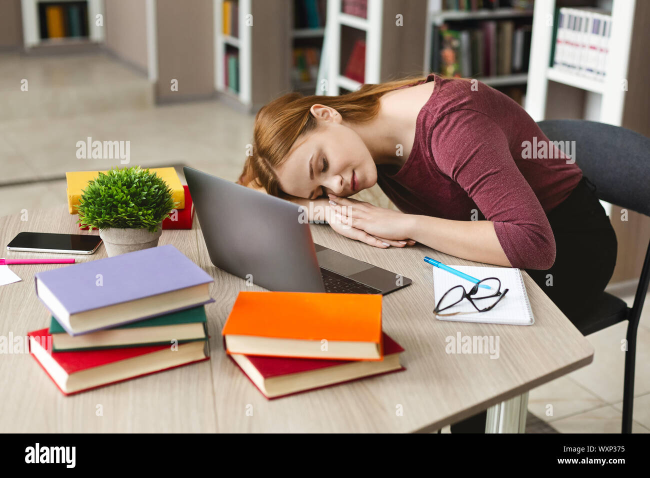 Exhausted girl having nap on workplace in front of laptop Stock Photo ...
