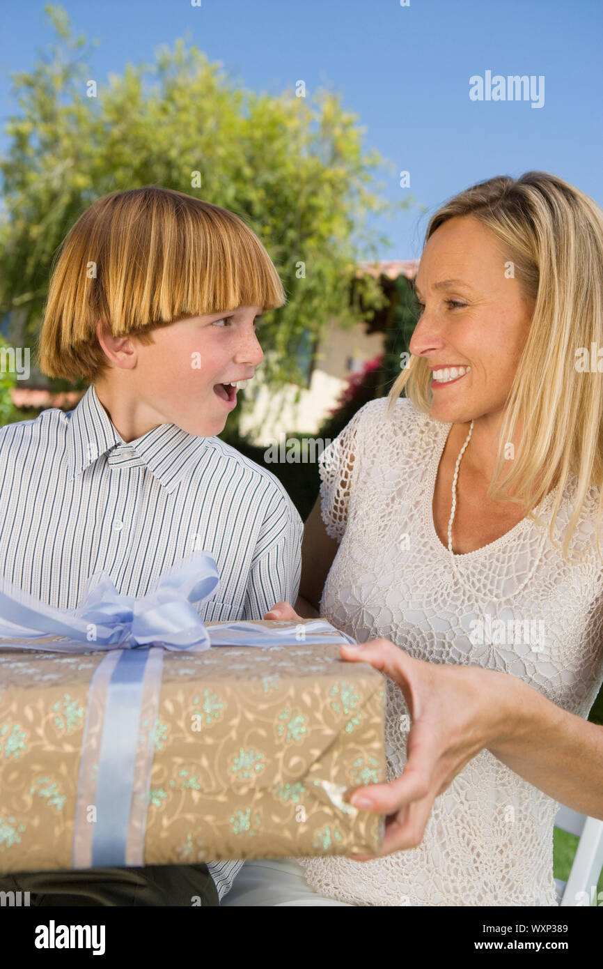 Boy giving birthday present to his mother Stock Photo - Alamy