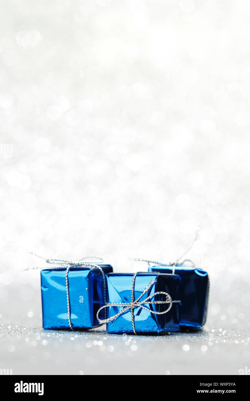 Blue Christmas gift boxes on shiny silver background Stock Photo - Alamy