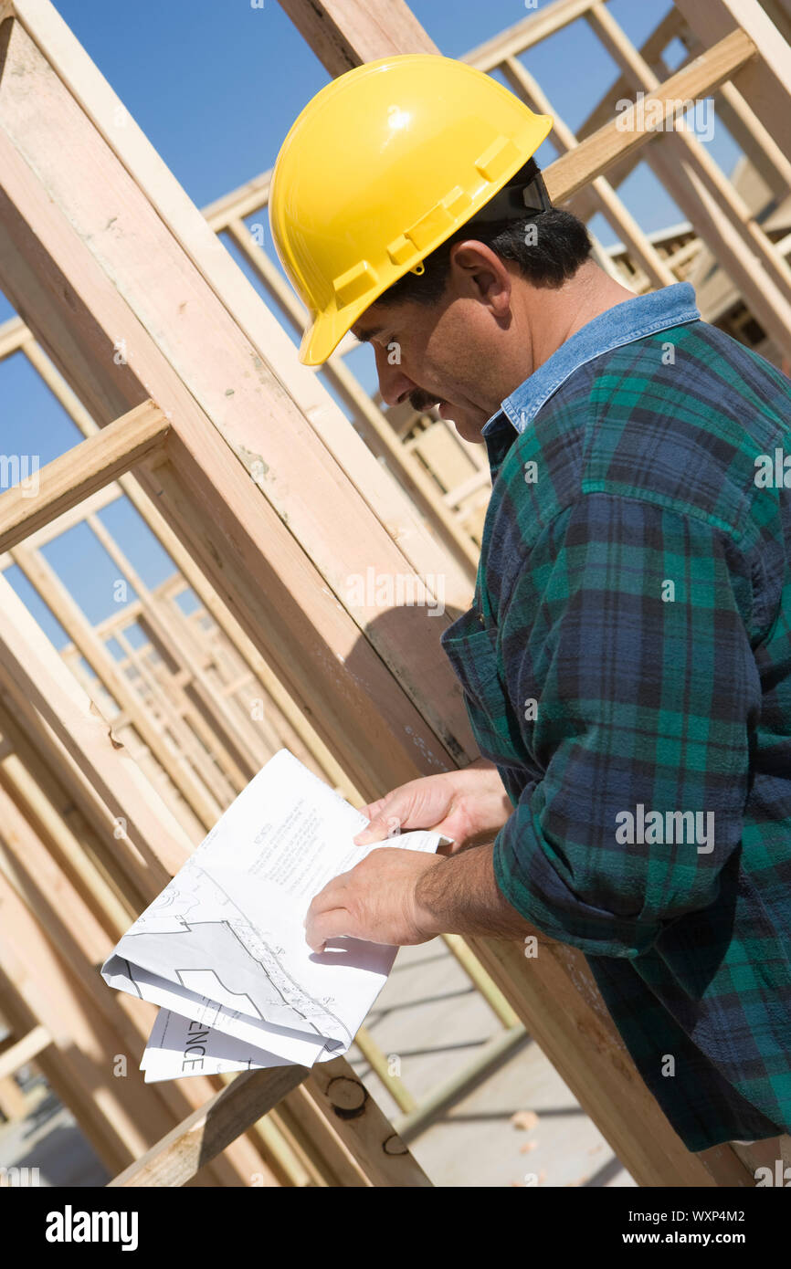 Construction Worker reading blueprint Stock Photo - Alamy