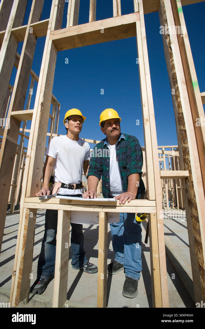 Construction workers standing on building site Stock Photo - Alamy