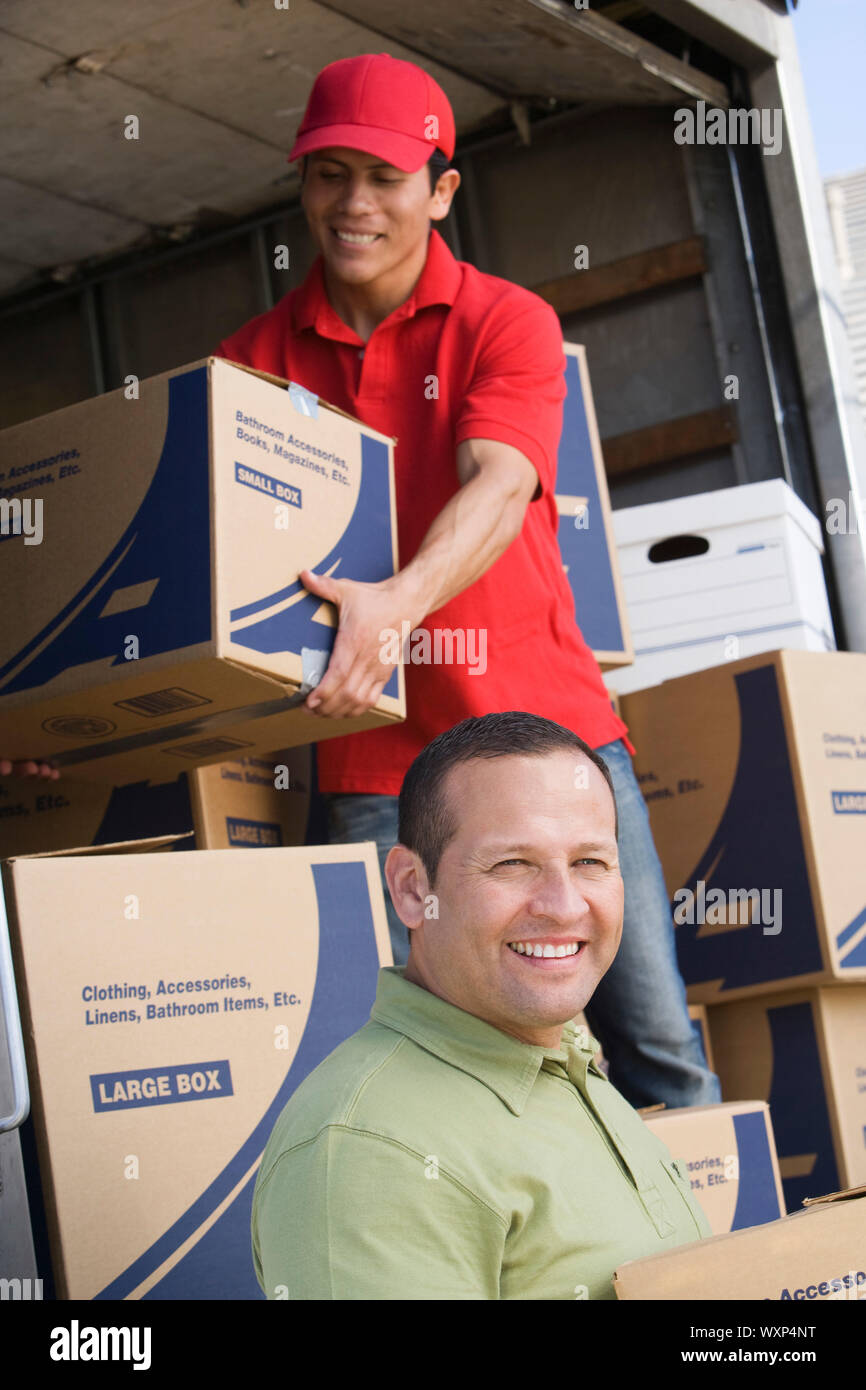 Two man unloading delivery van Stock Photo - Alamy