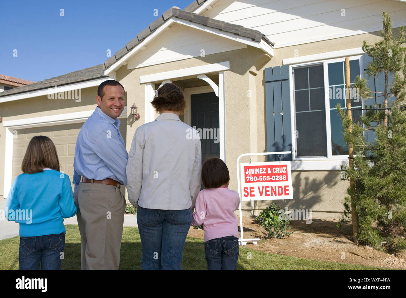 Family with two children (6-8) in front of new house, back view Stock ...