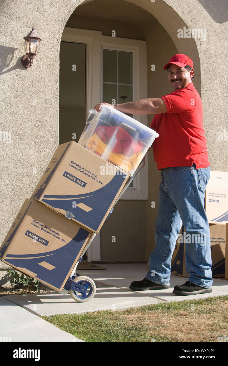 Delivery man holding cart with stack of containers Stock Photo - Alamy