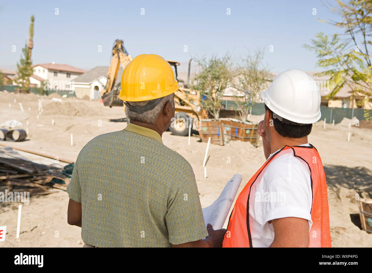 Surveyor and contraction worker at construction site, back view Stock ...