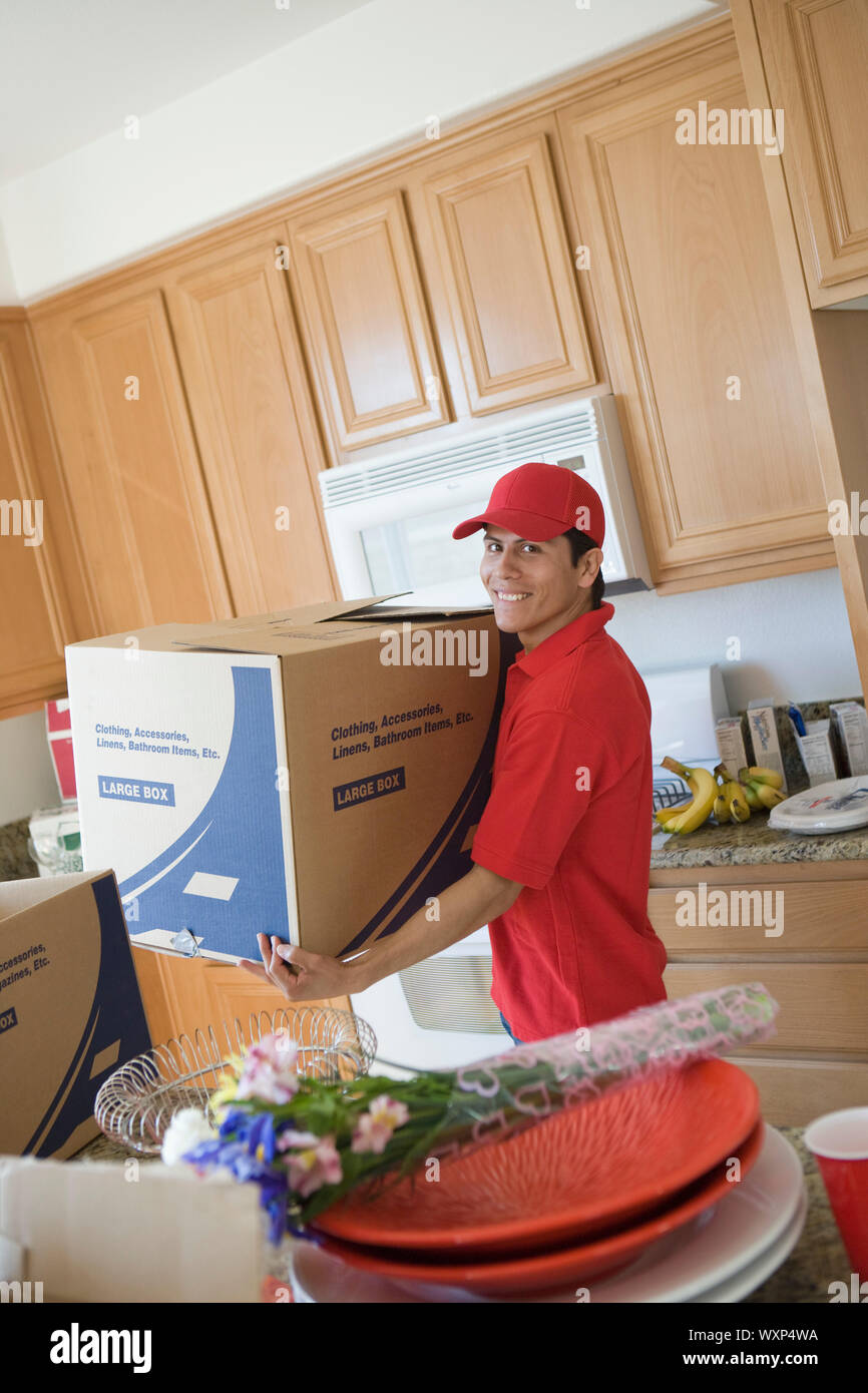 Man carrying a box in kitchen Stock Photo - Alamy