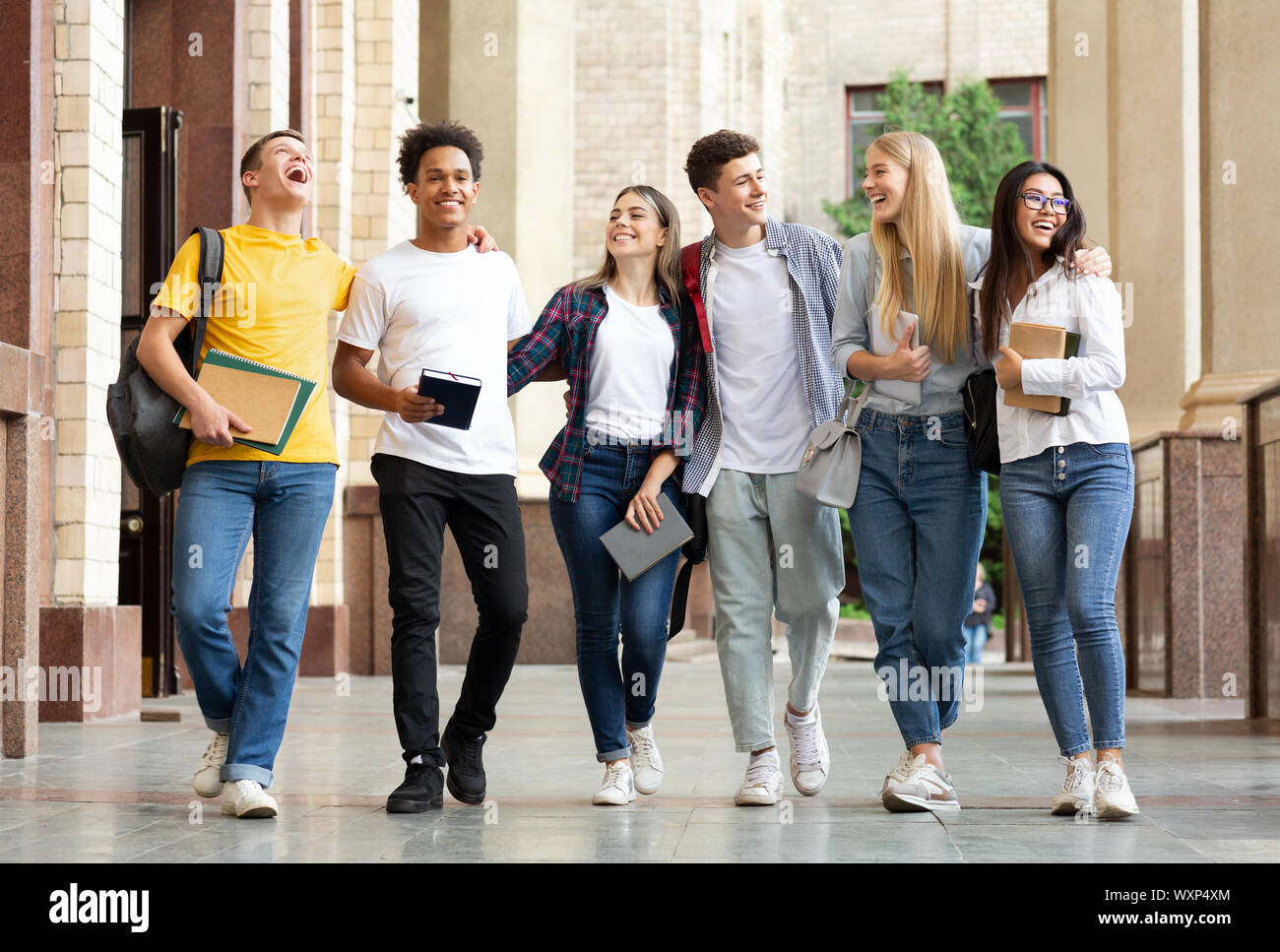 Multiracial students walking after classes in university campus Stock ...