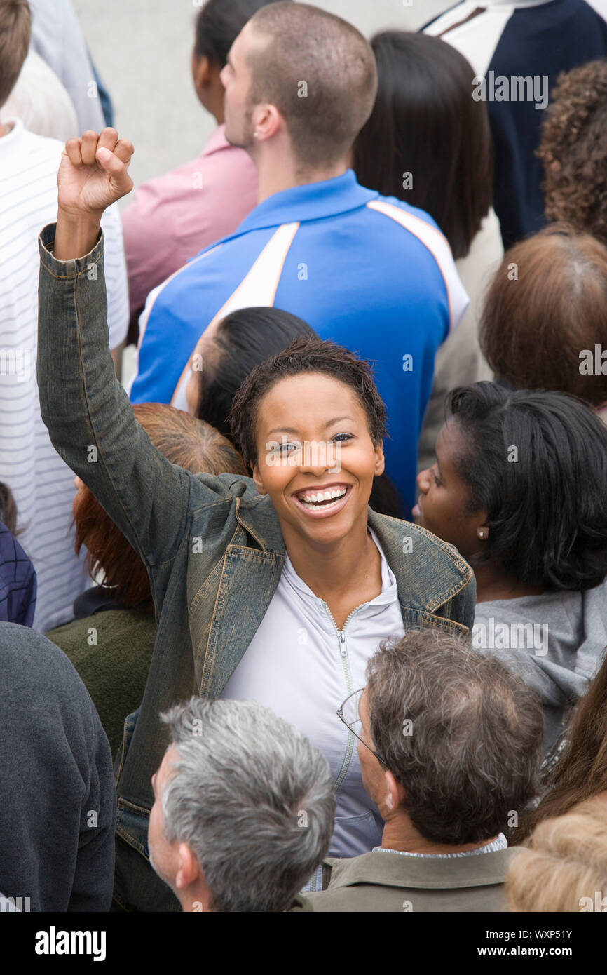 Woman with arm raised in crowd Stock Photo - Alamy