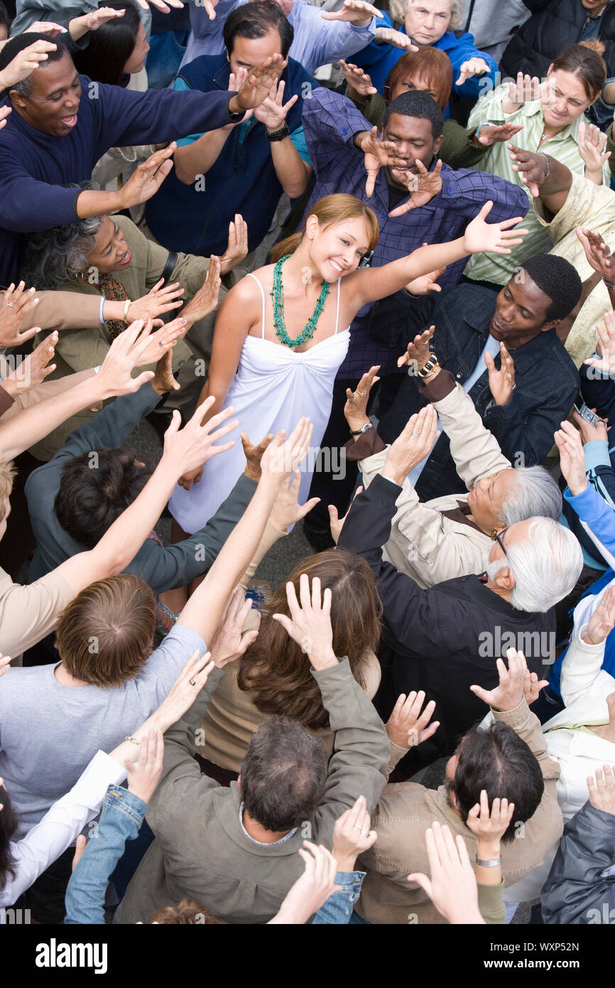 Young woman surrounded by crowd Stock Photo - Alamy