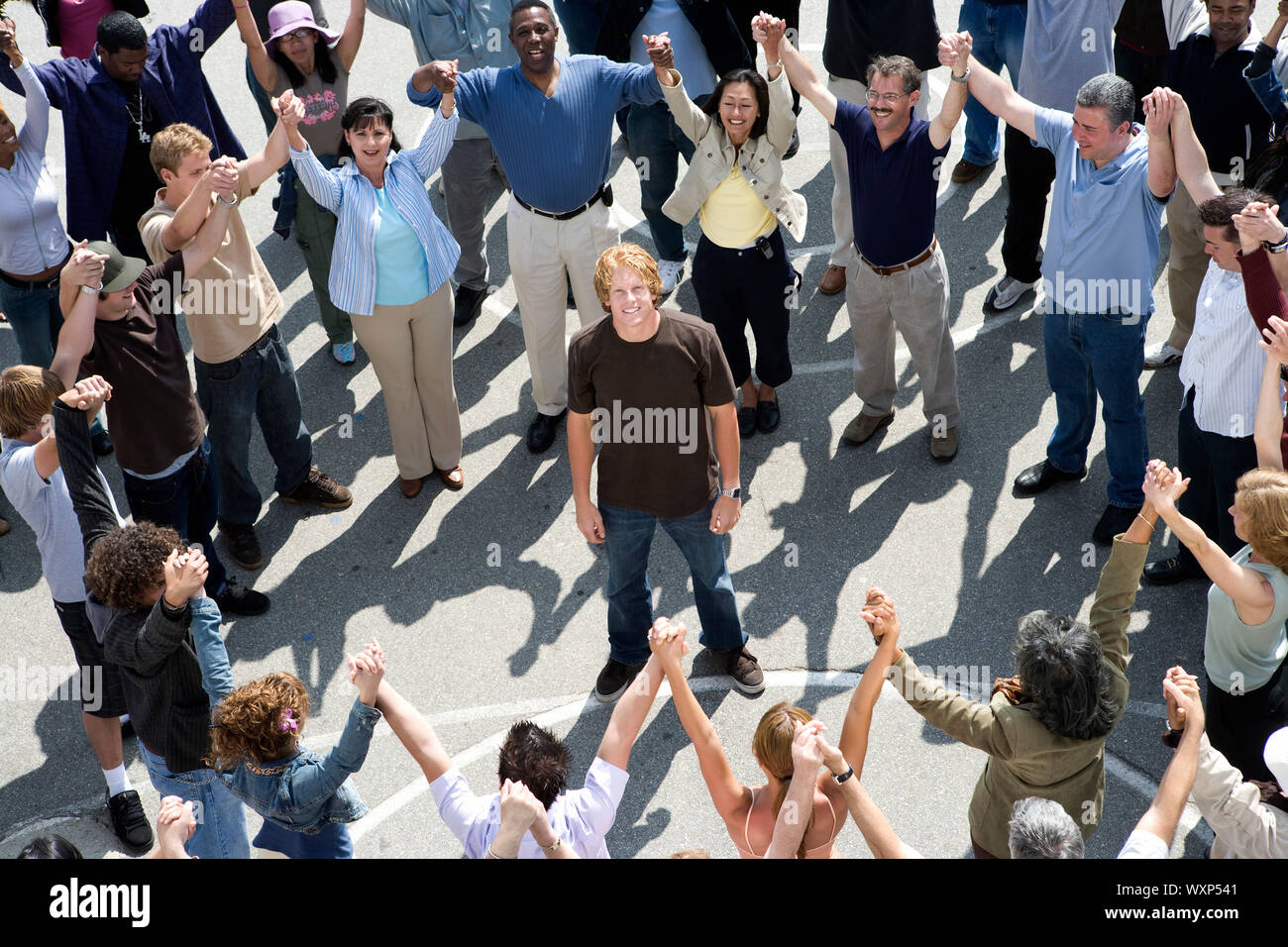 Crowd with arms raised surrounding young man Stock Photo - Alamy