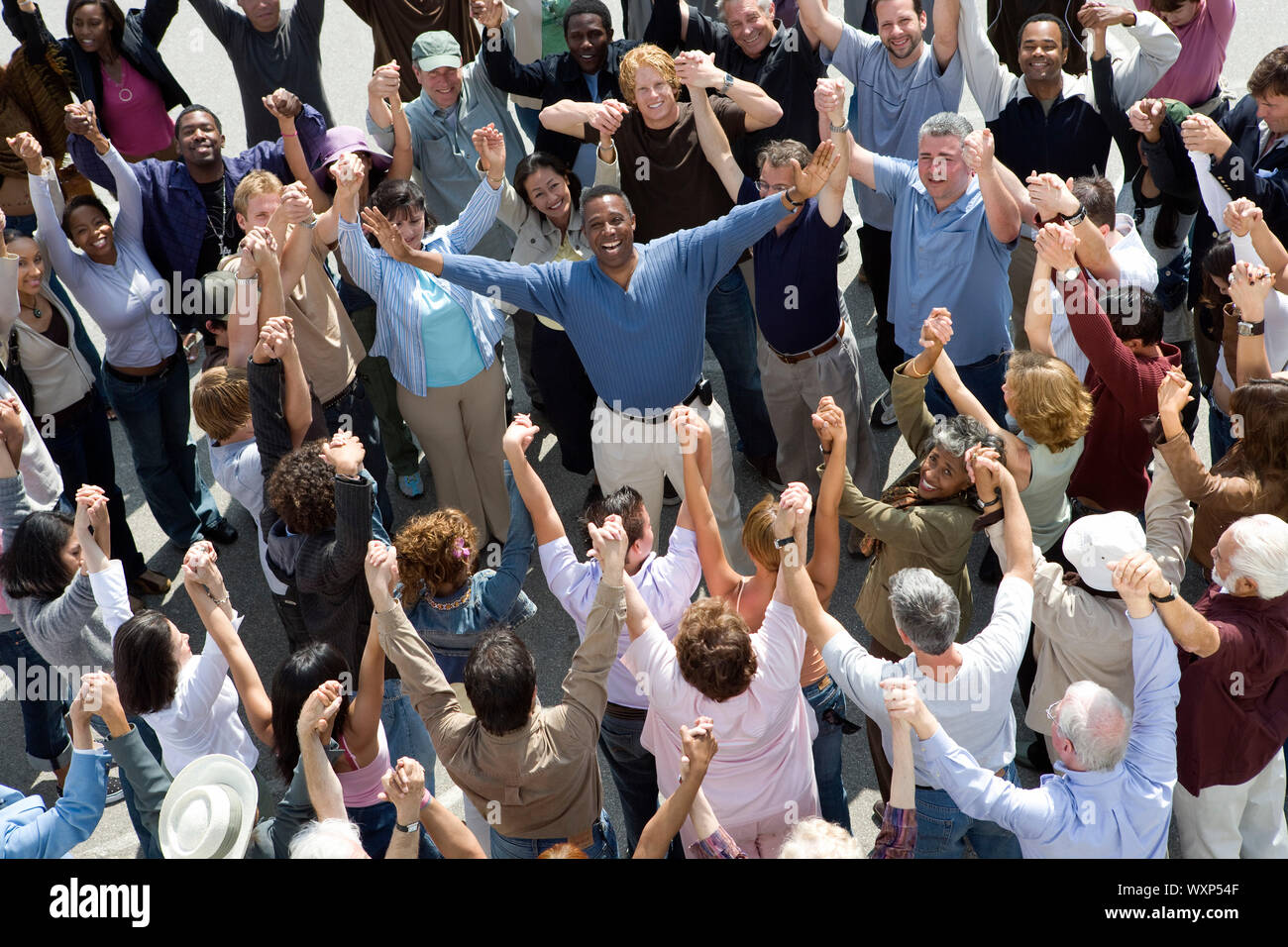 Crowd with arms raised surrounding man Stock Photo - Alamy
