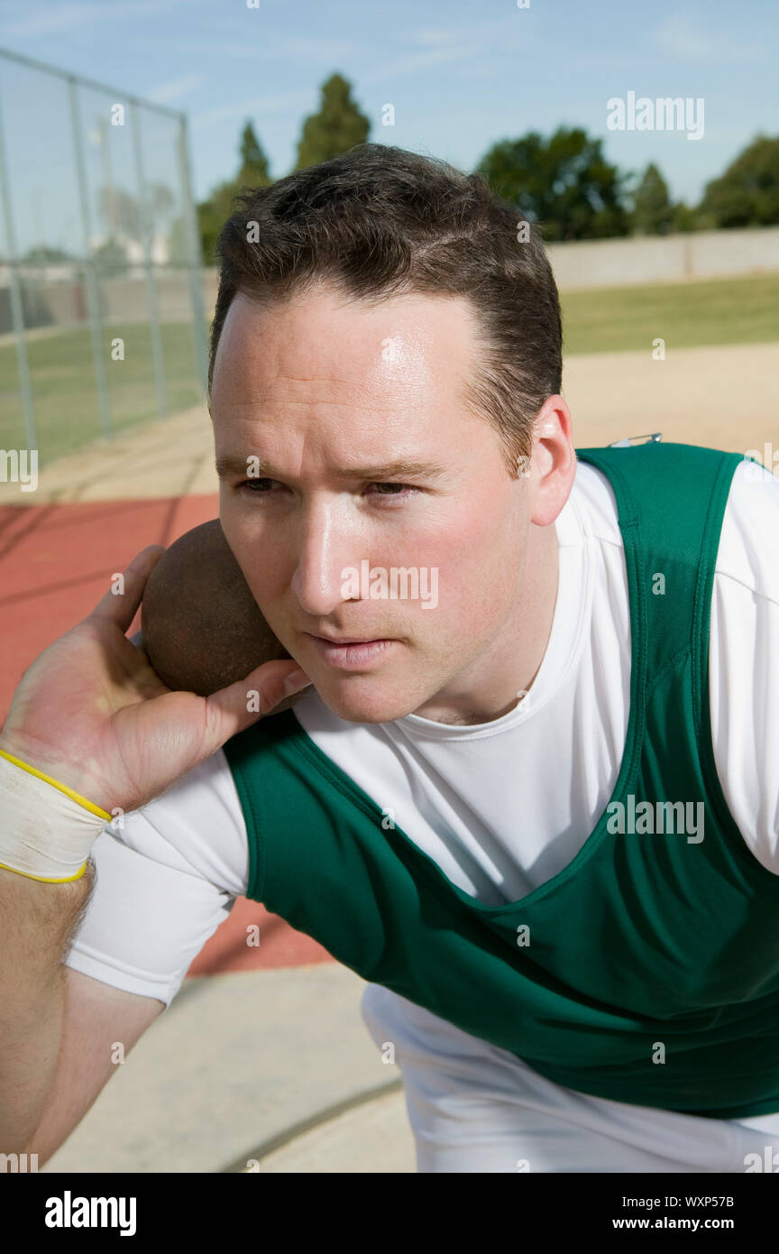 Male shot putter holding shot Stock Photo - Alamy