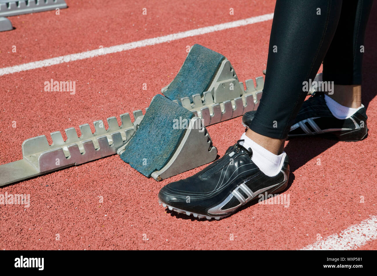 Male sprinter by track starting block Stock Photo - Alamy