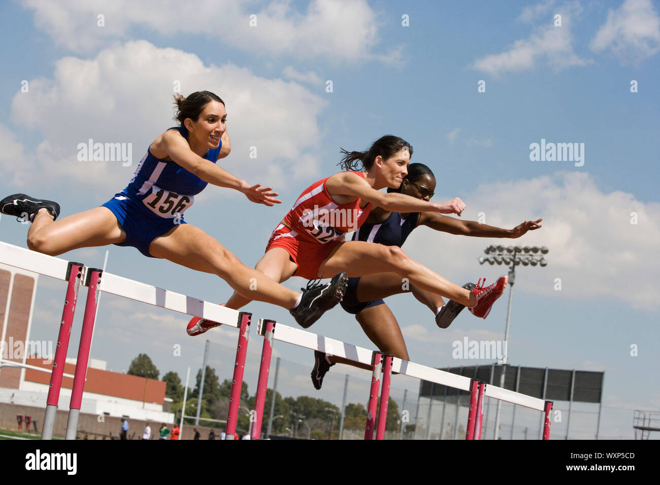 Female athletes hurdling Stock Photo - Alamy