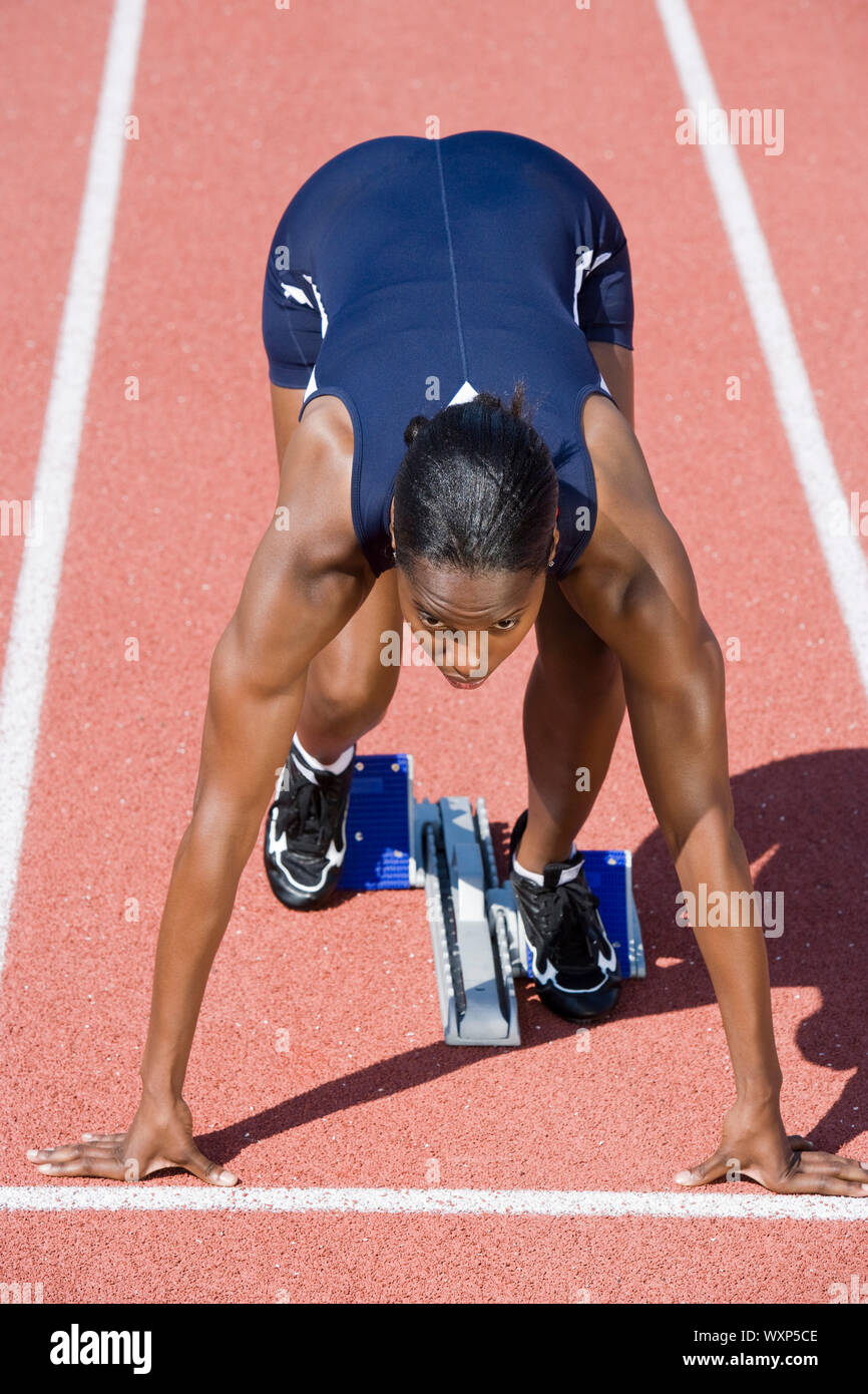 Female athlete in starting block, ready to run Stock Photo - Alamy