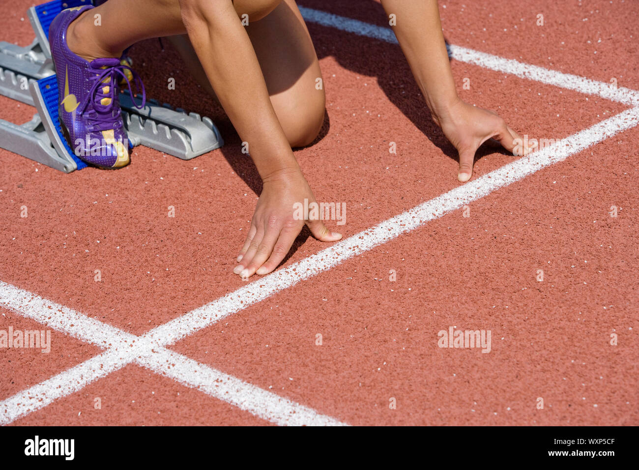 Female athlete in starting block, ready to run Stock Photo - Alamy