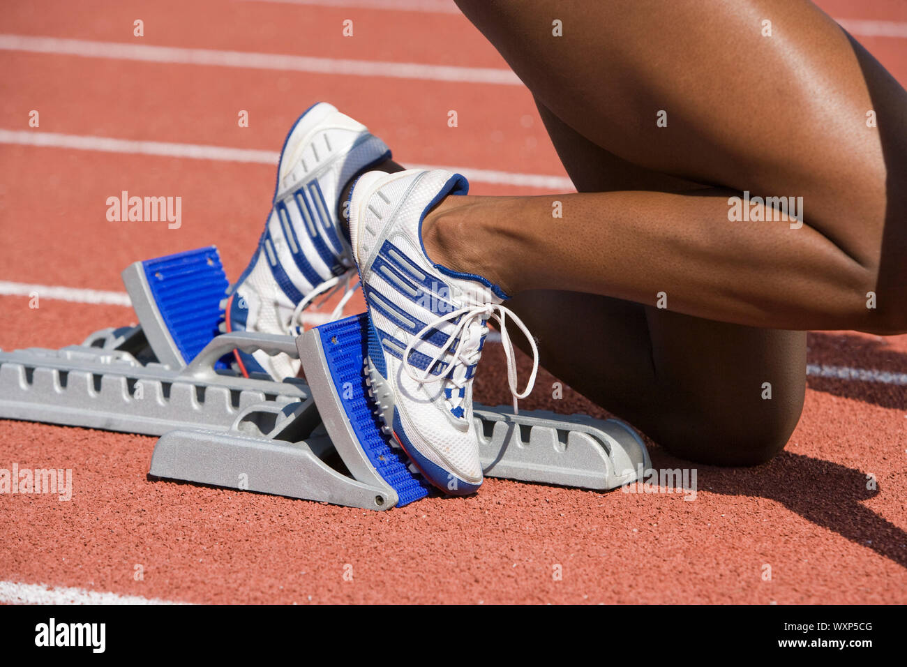Female athlete in starting block, ready to run Stock Photo - Alamy