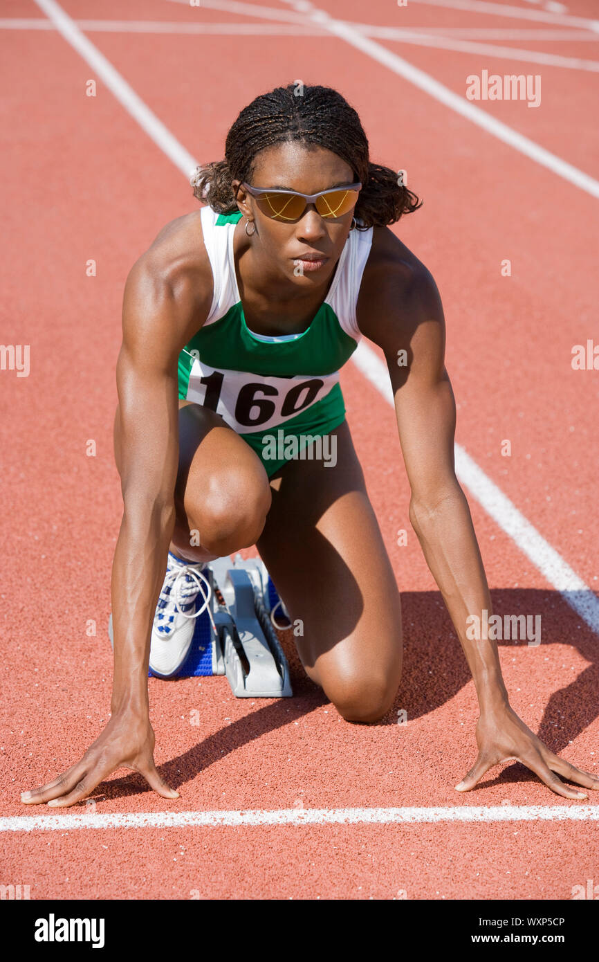 Female athlete in starting block, ready to run Stock Photo - Alamy