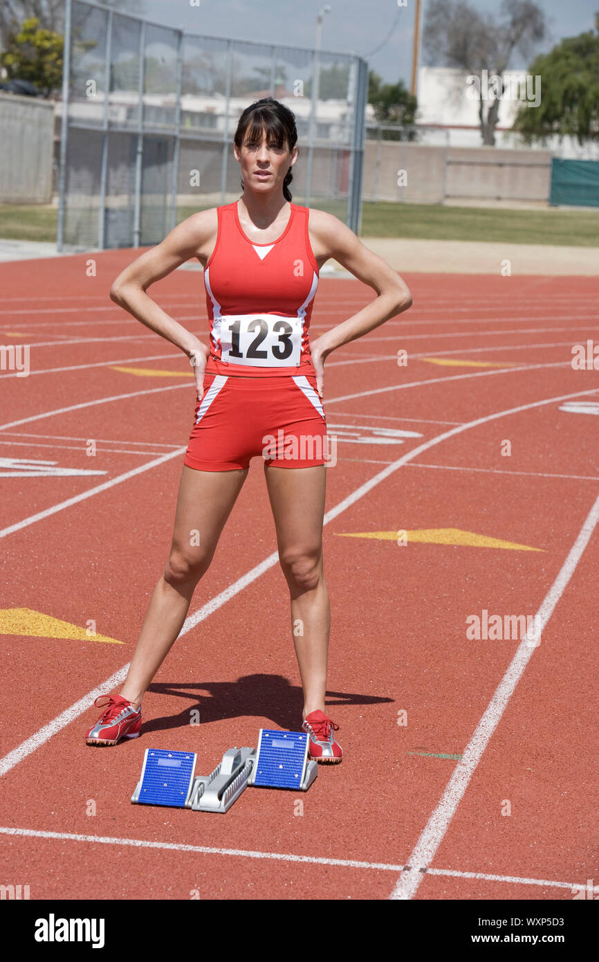 Female athlete next to starting block, ready to run Stock Photo - Alamy