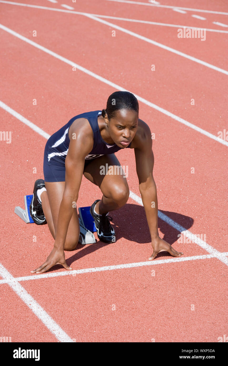 Female athlete in starting block, ready to run Stock Photo - Alamy