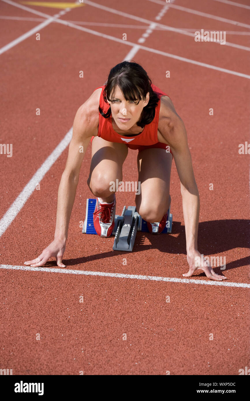 Female athlete in starting block, ready to run Stock Photo - Alamy
