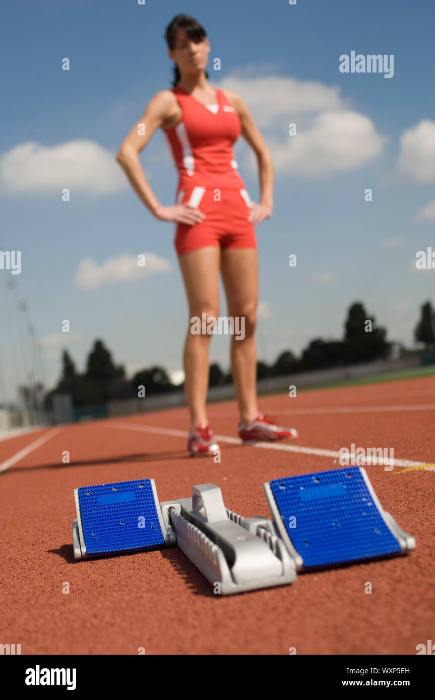 Starting block with Female track athlete standing in background Stock ...