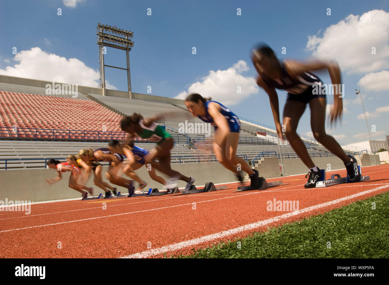 Group of female track athletes sprinting Stock Photo - Alamy