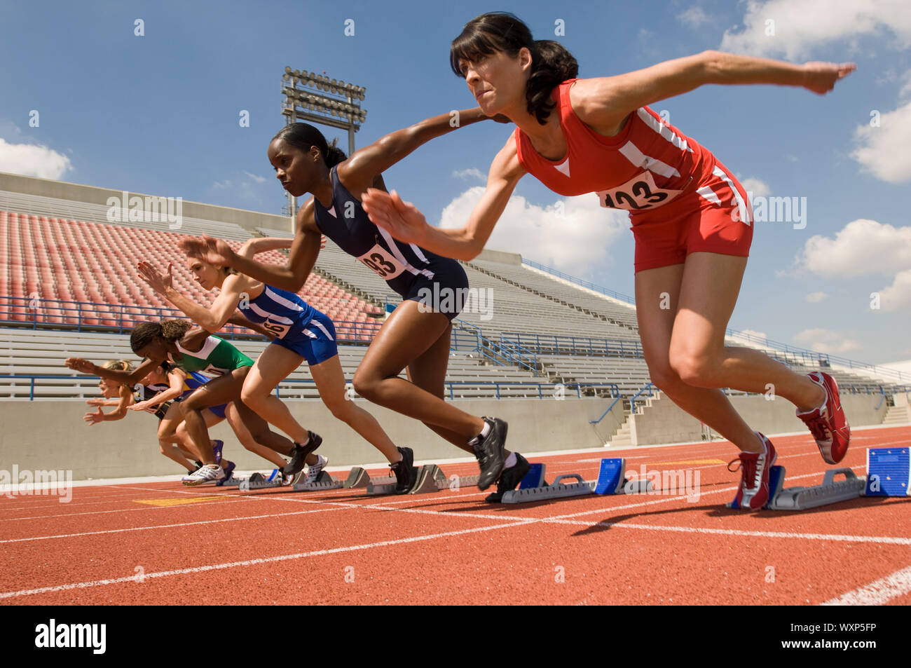 Group of female track athletes sprinting Stock Photo - Alamy