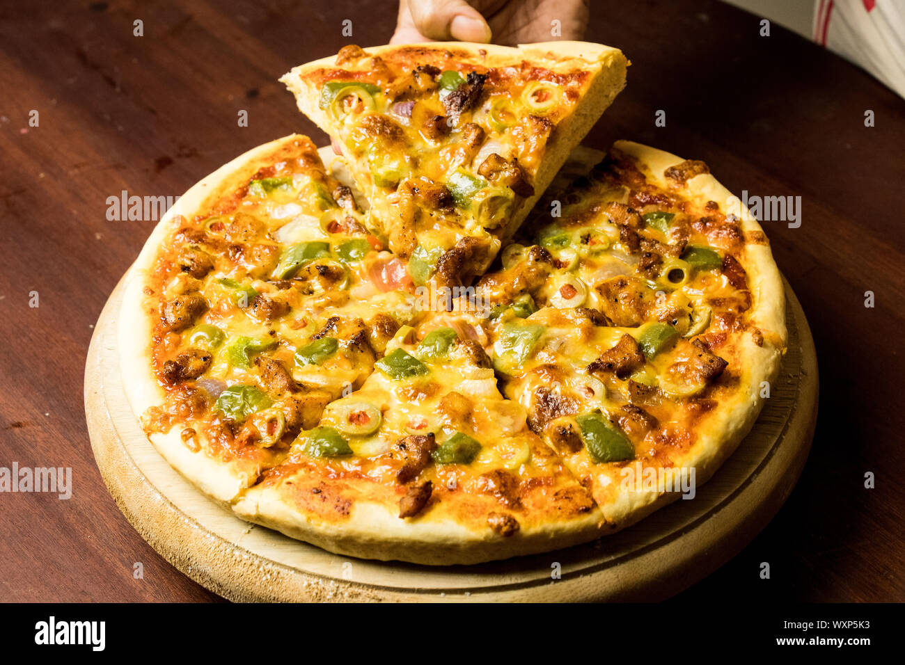 Pan Pizza slice take from hand Stock Photo - Alamy