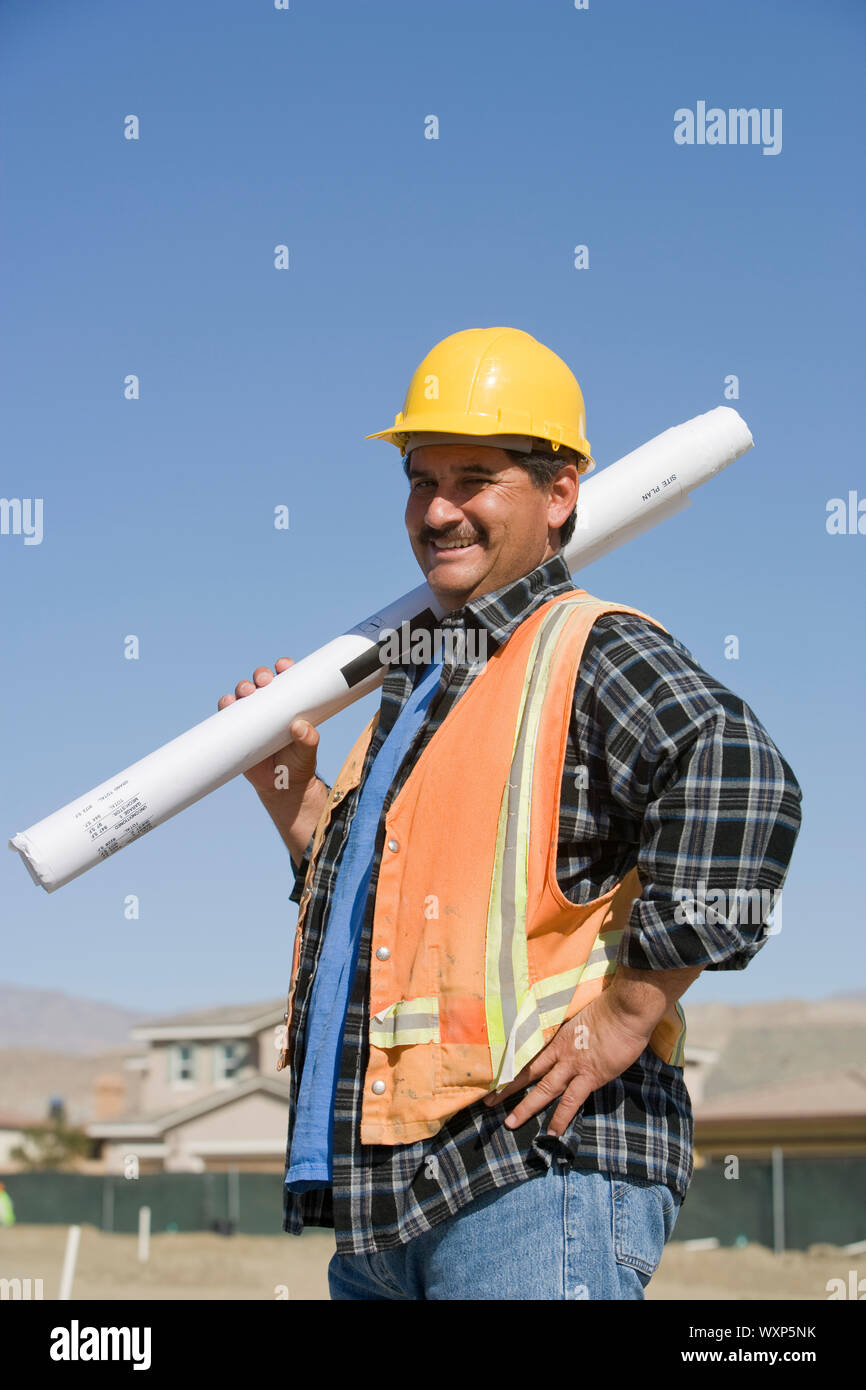 Construction worker holding building plans Stock Photo - Alamy
