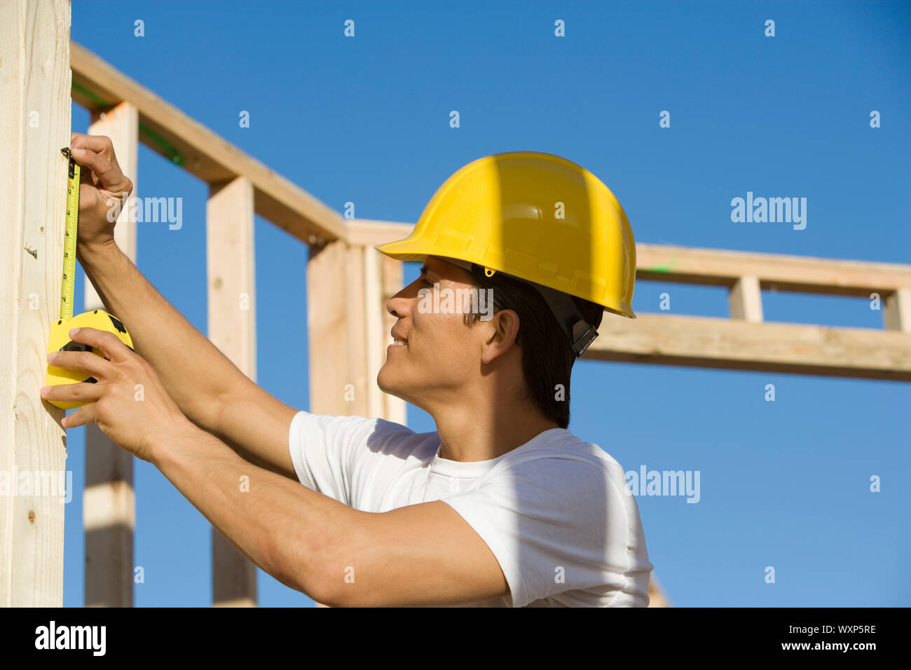 Construction worker measuring building construction Stock Photo - Alamy