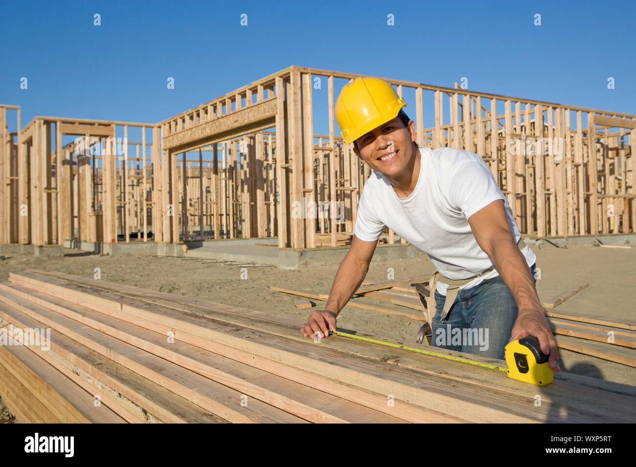 Construction worker measuring wooden planks Stock Photo - Alamy