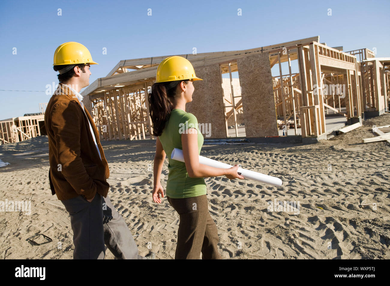 Mid adult man and young woman in construction site Stock Photo - Alamy