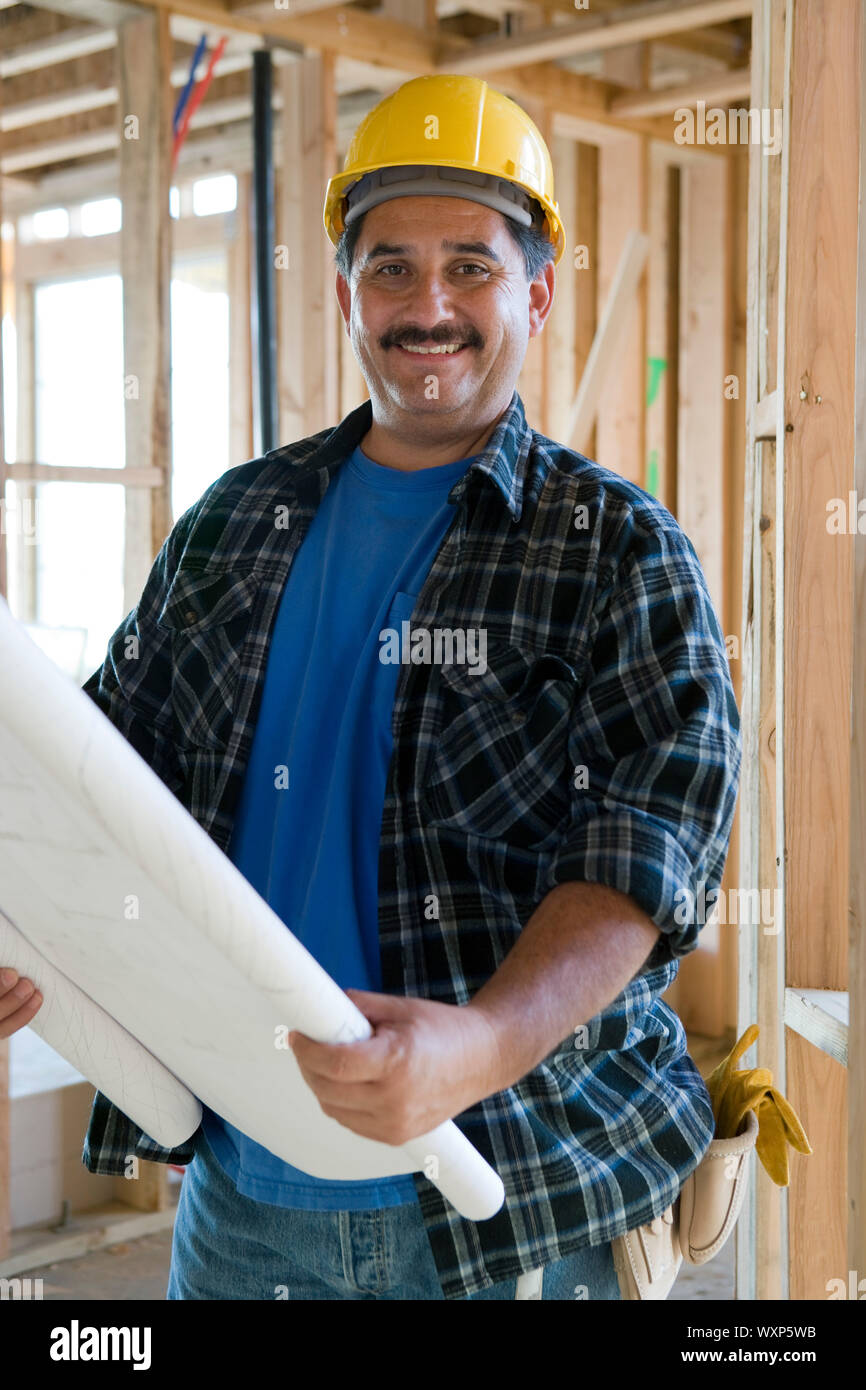 Worker holding blueprint in construction site Stock Photo - Alamy