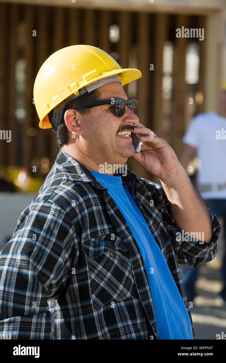 Worker using mobile phone in construction site Stock Photo - Alamy