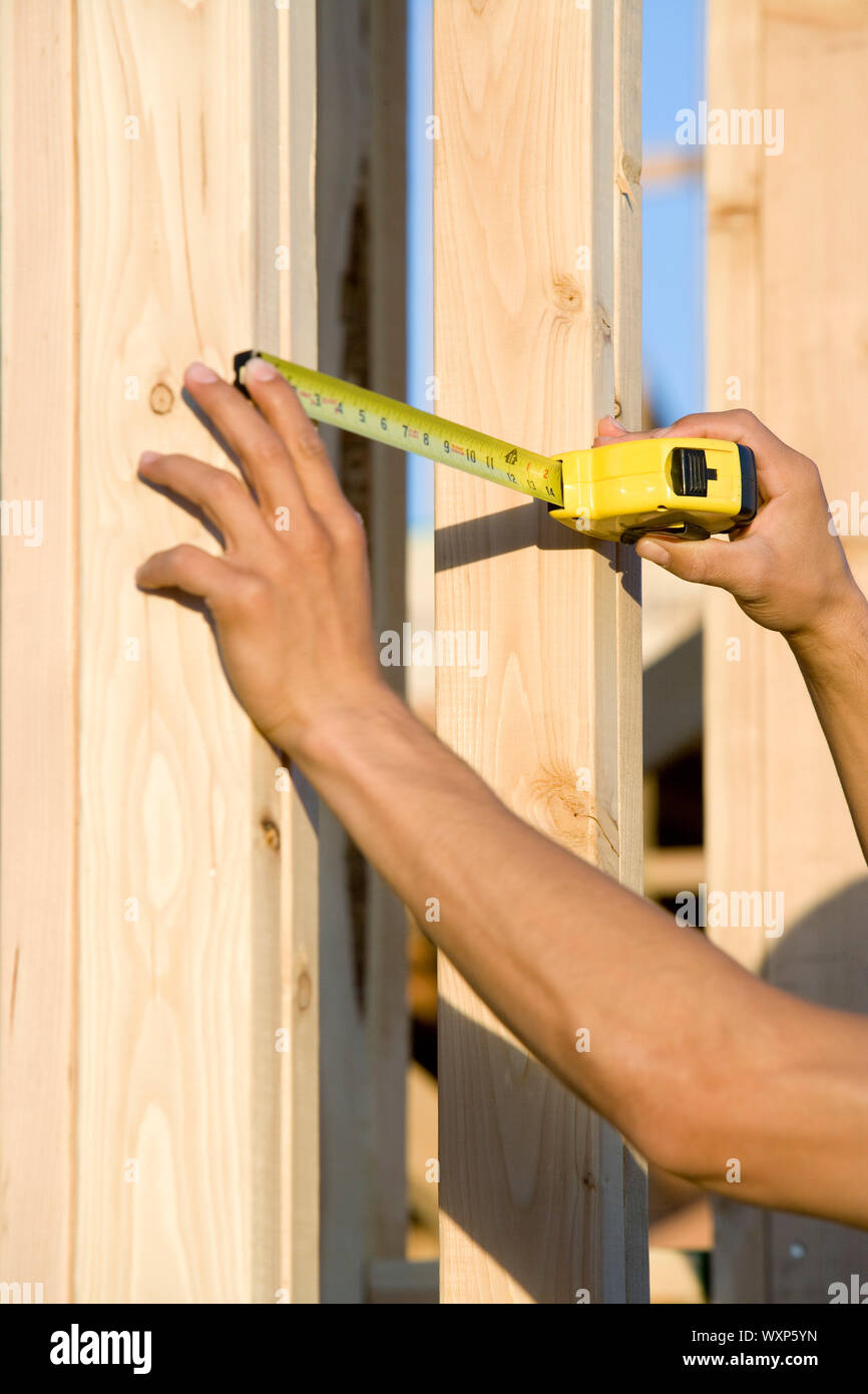Measuring wooden elements of house construction Stock Photo - Alamy