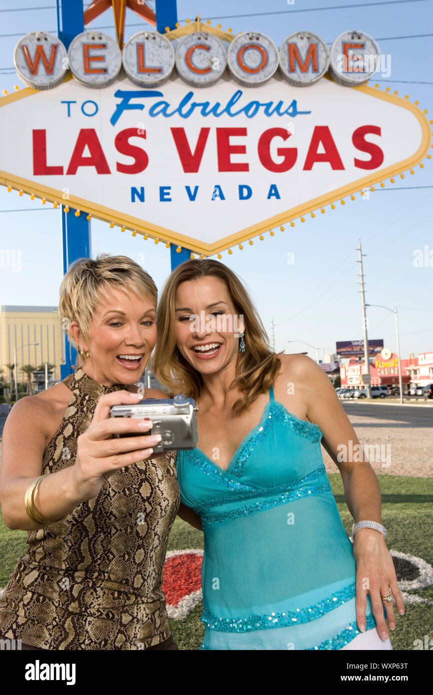 Two women in front of Welcome to Las Vegas sign Stock Photo - Alamy