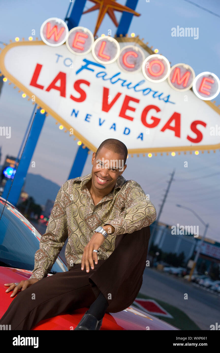 Man sitting on bonnet of car in Las Vegas Stock Photo - Alamy