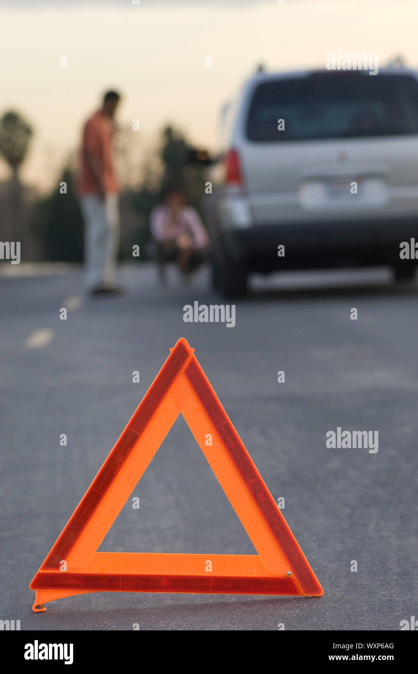 Warning triangle in front of broken down car Stock Photo - Alamy